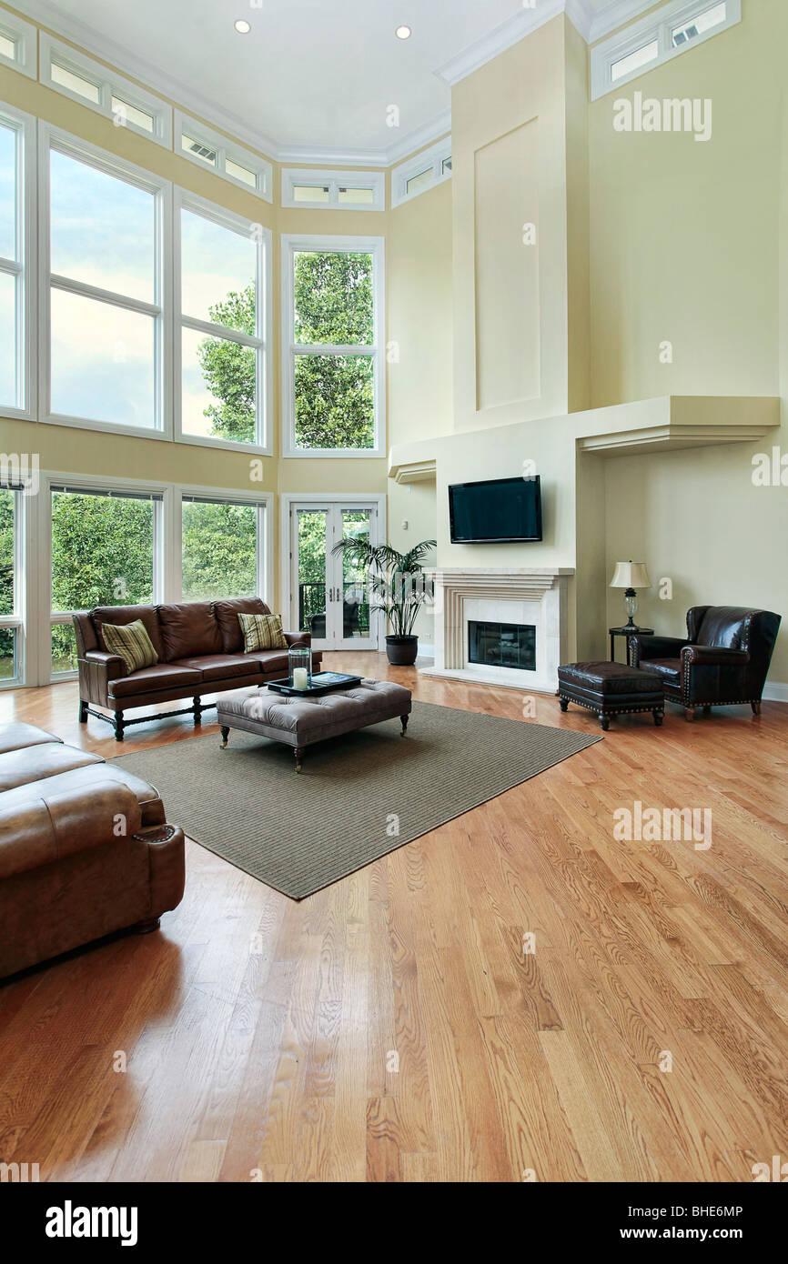 Living room in luxury home with two story windows Stock Photo - Alamy