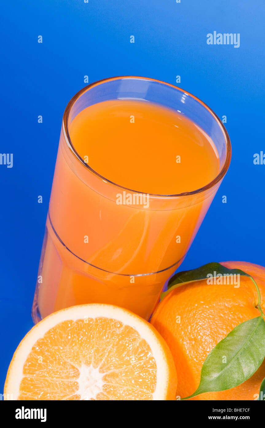 Fresh orange food and juice over blue background Stock Photo - Alamy