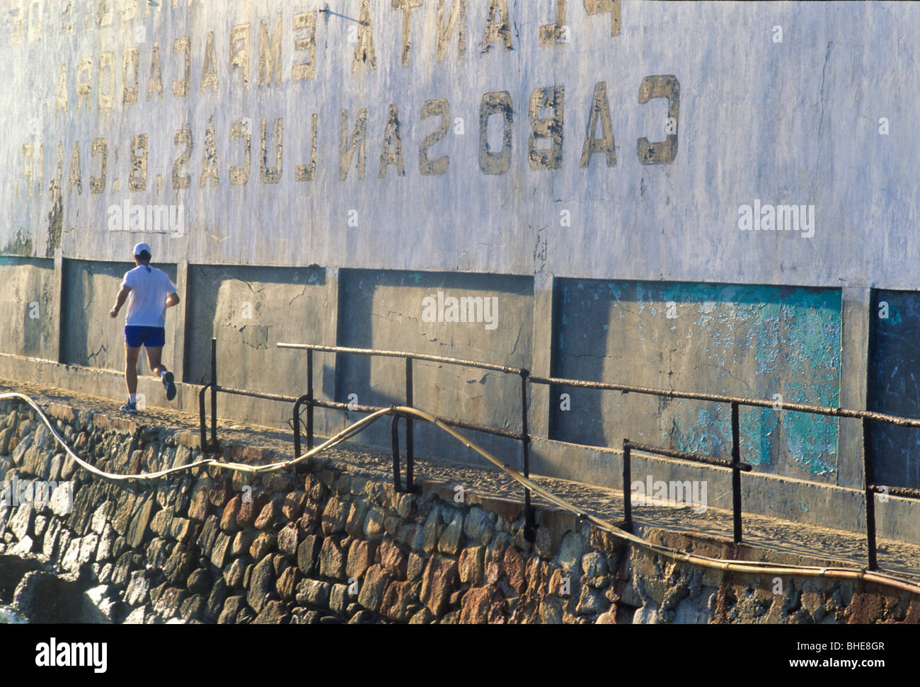 Man running along side of building Stock Photo - Alamy
