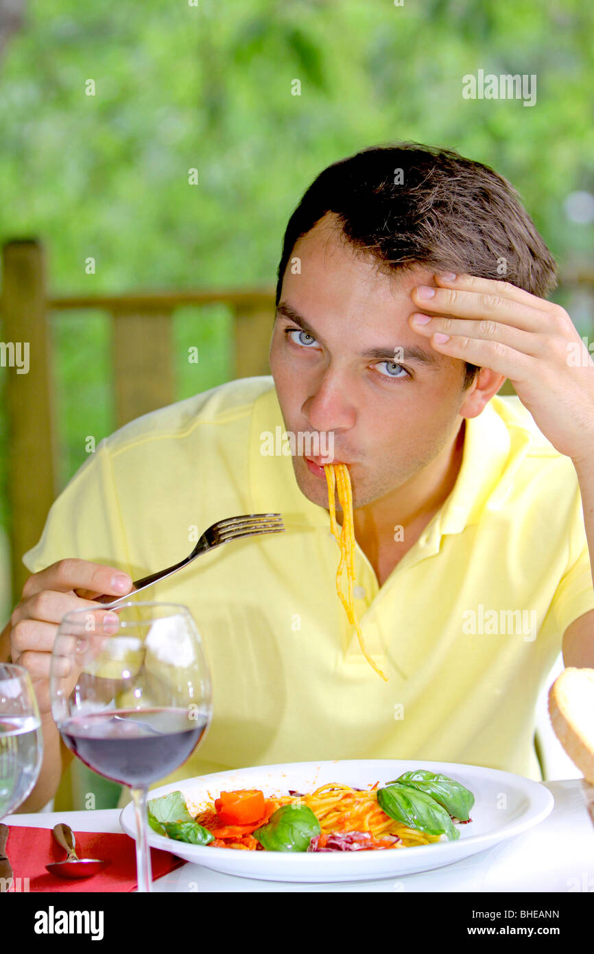 bored man eating spaghetti in the holidays Stock Photo - Alamy