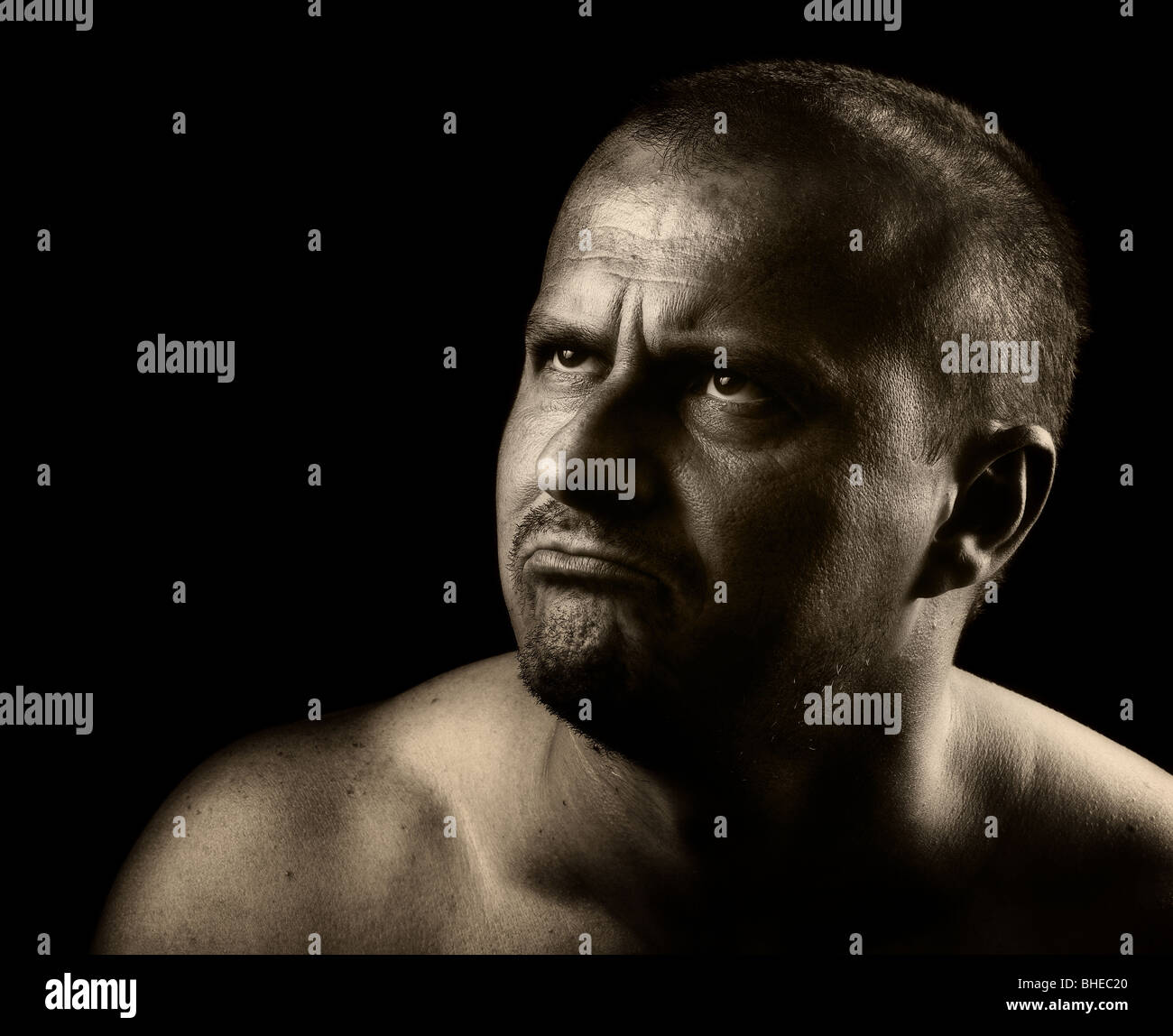 High impact portrait of an angry man, isolated on black background ...