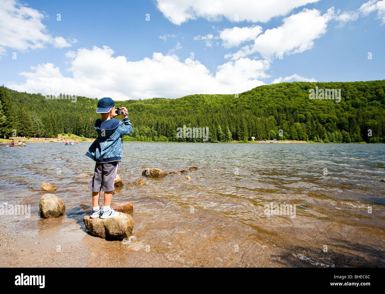 Boy filming the beautiful landscape with a lake and pine forest Stock ...