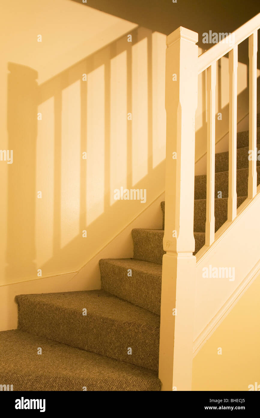 Shadow from the spindles of a staircase fall upon the wall behind the ...