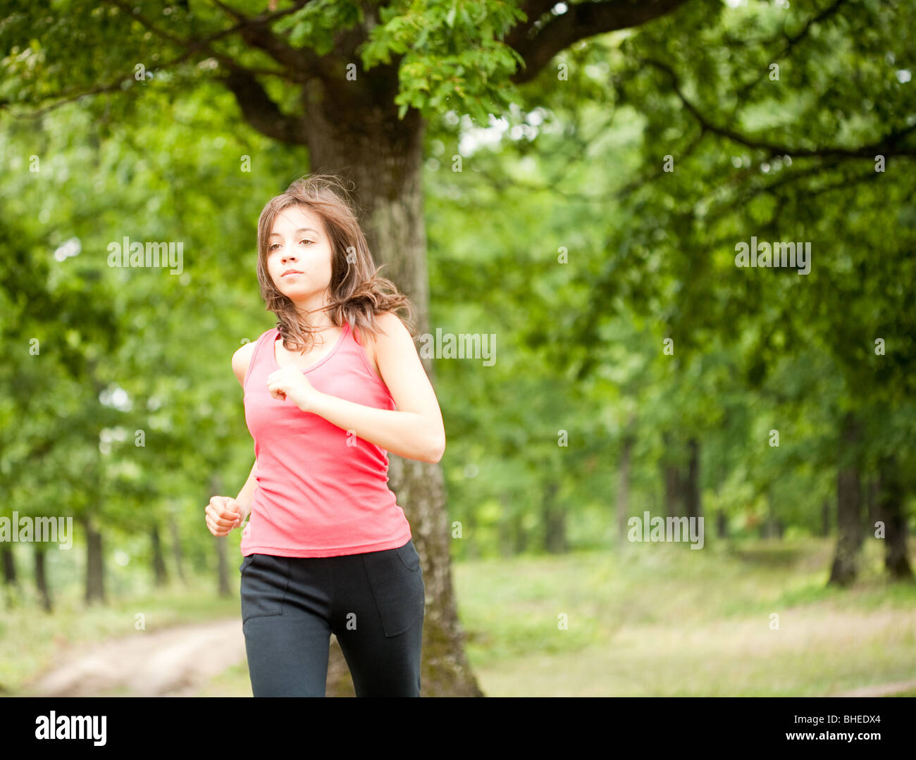 Young woman running outdoor through a forest Stock Photo - Alamy