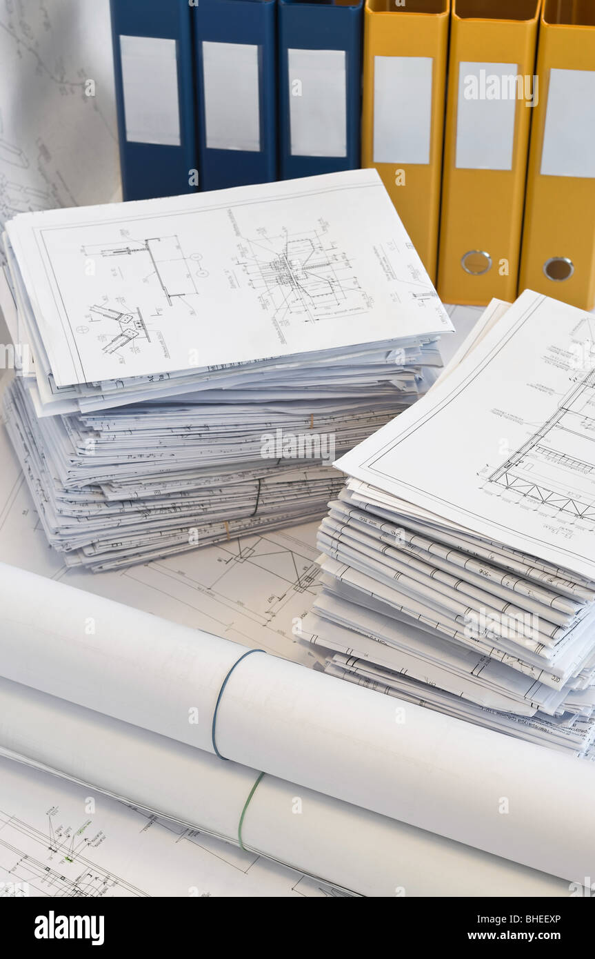 Big heap of design and project drawings in yellow folder on the table ...