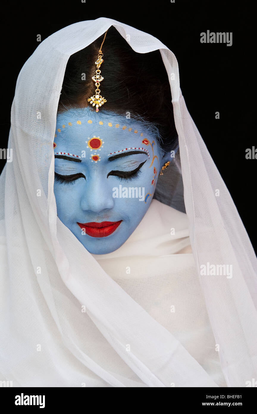 Indian girl, face painted as the Hindu goddess Sita against a black ...