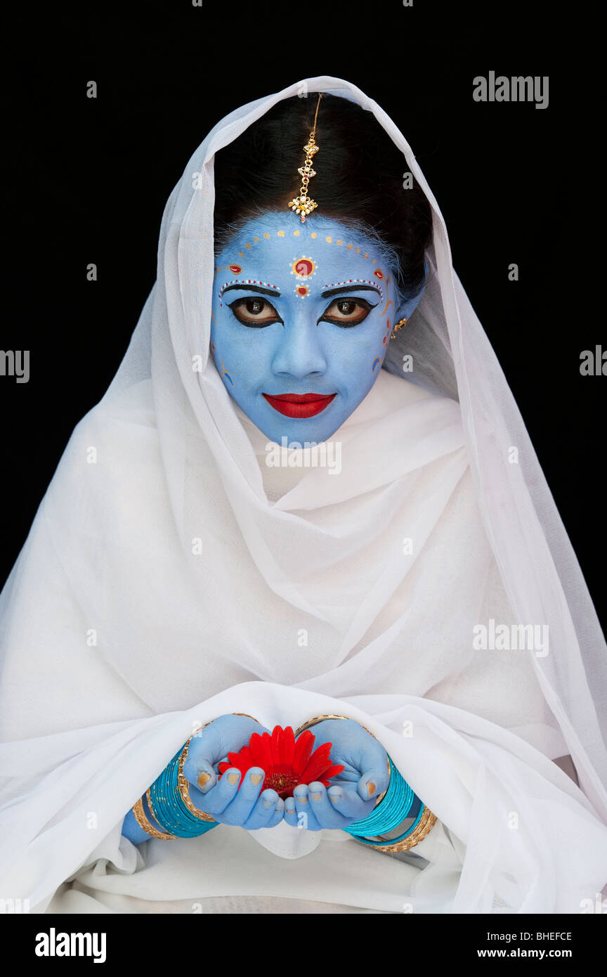 Indian girl, face painted as the Hindu goddess Sita against a black ...