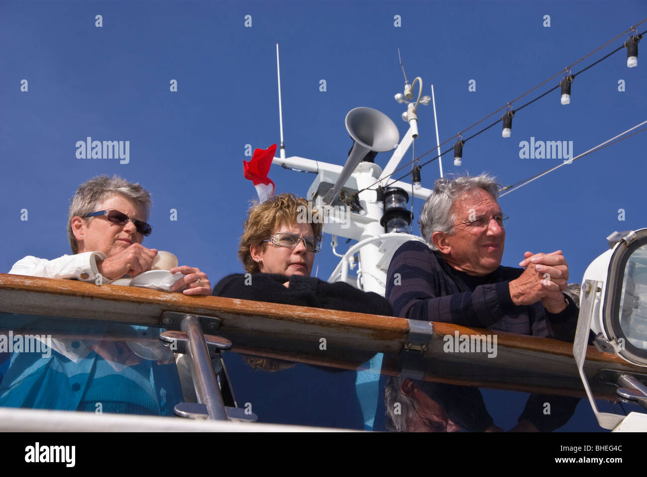 Passengers on a cruise ship watch activities as ship prepares to sail ...