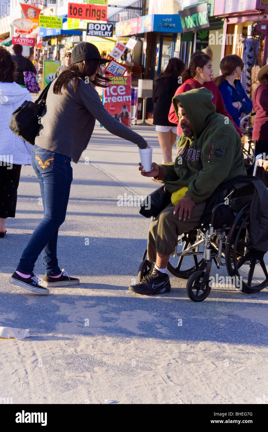 Handicapped Beggar gets help Stock Photo - Alamy