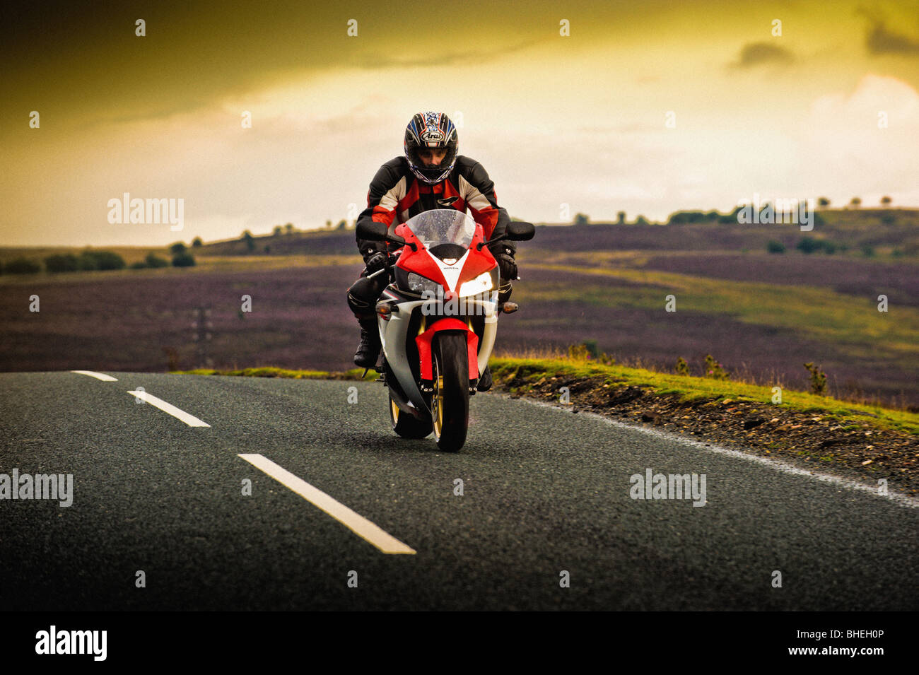 Front view of motorbike and rider on road on the North Yorkshire Moors ...