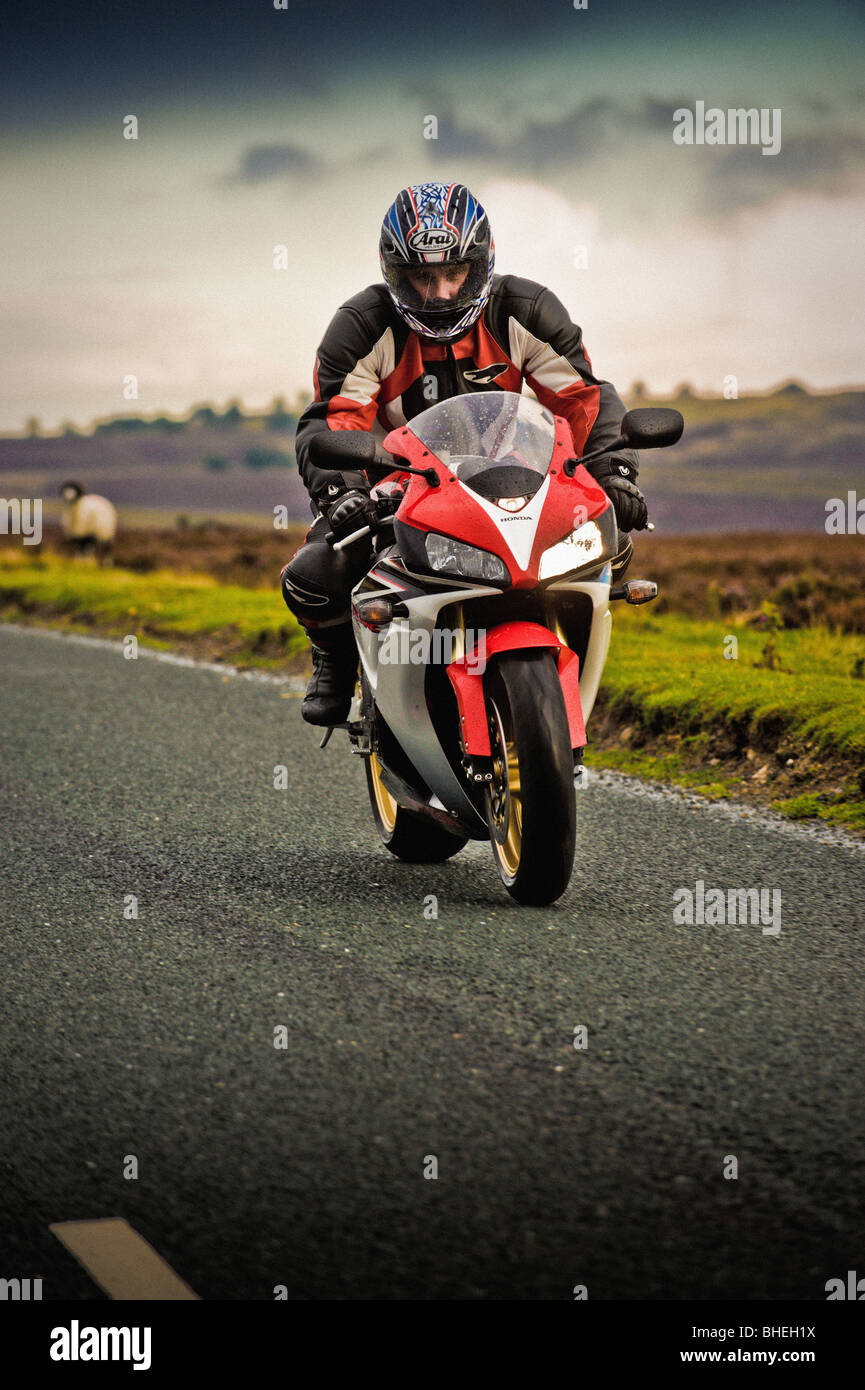 Front view of motorbike and rider on road on the North Yorkshire Moors ...