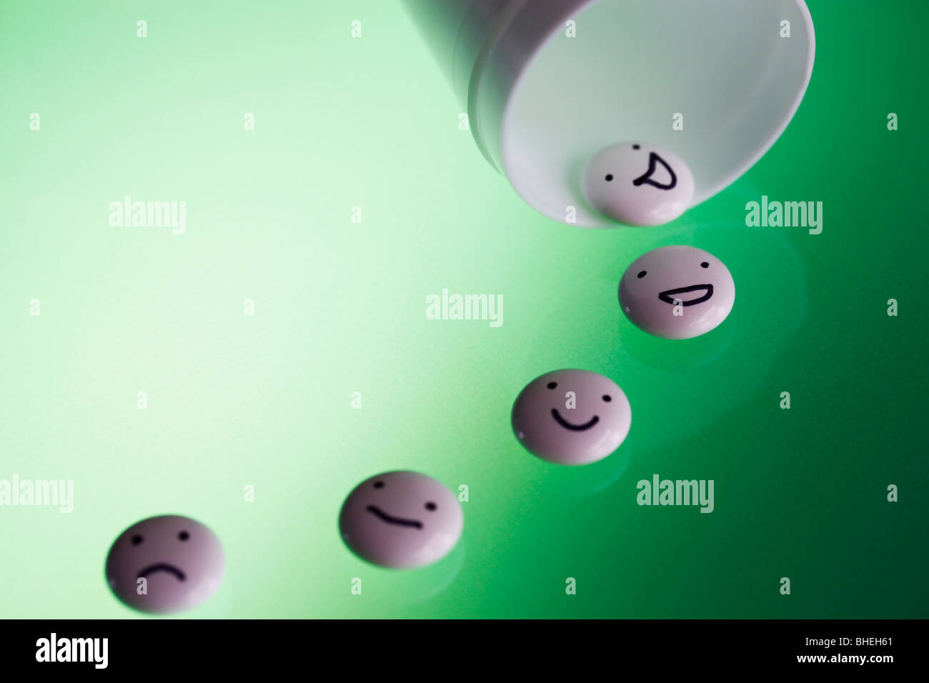 White tablets with mood faces on green background Stock Photo - Alamy