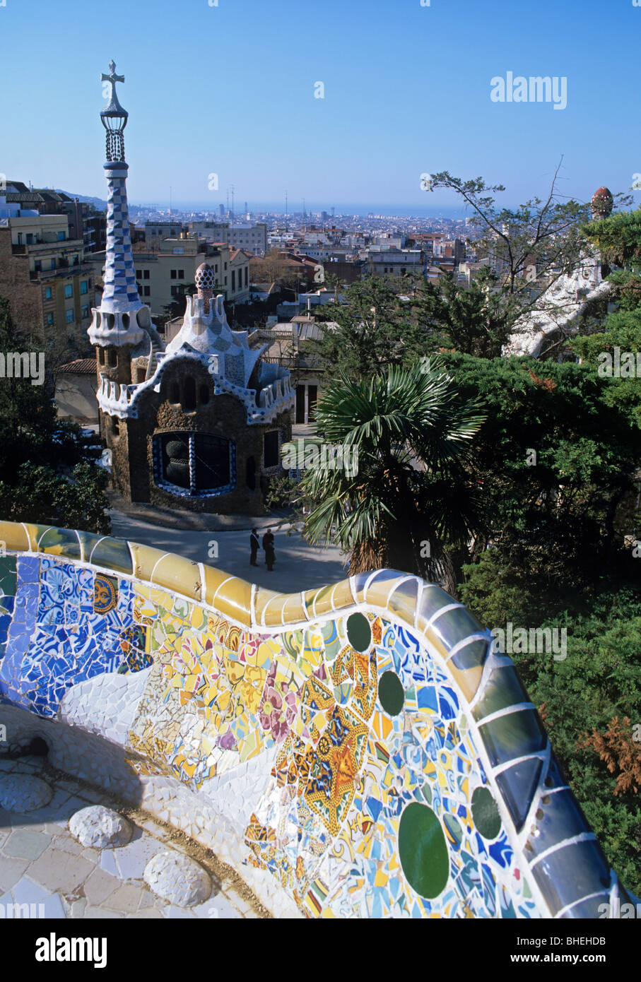 Tiled benches and gatehouse at Parc Guell designed by Antoni Gaudi ...