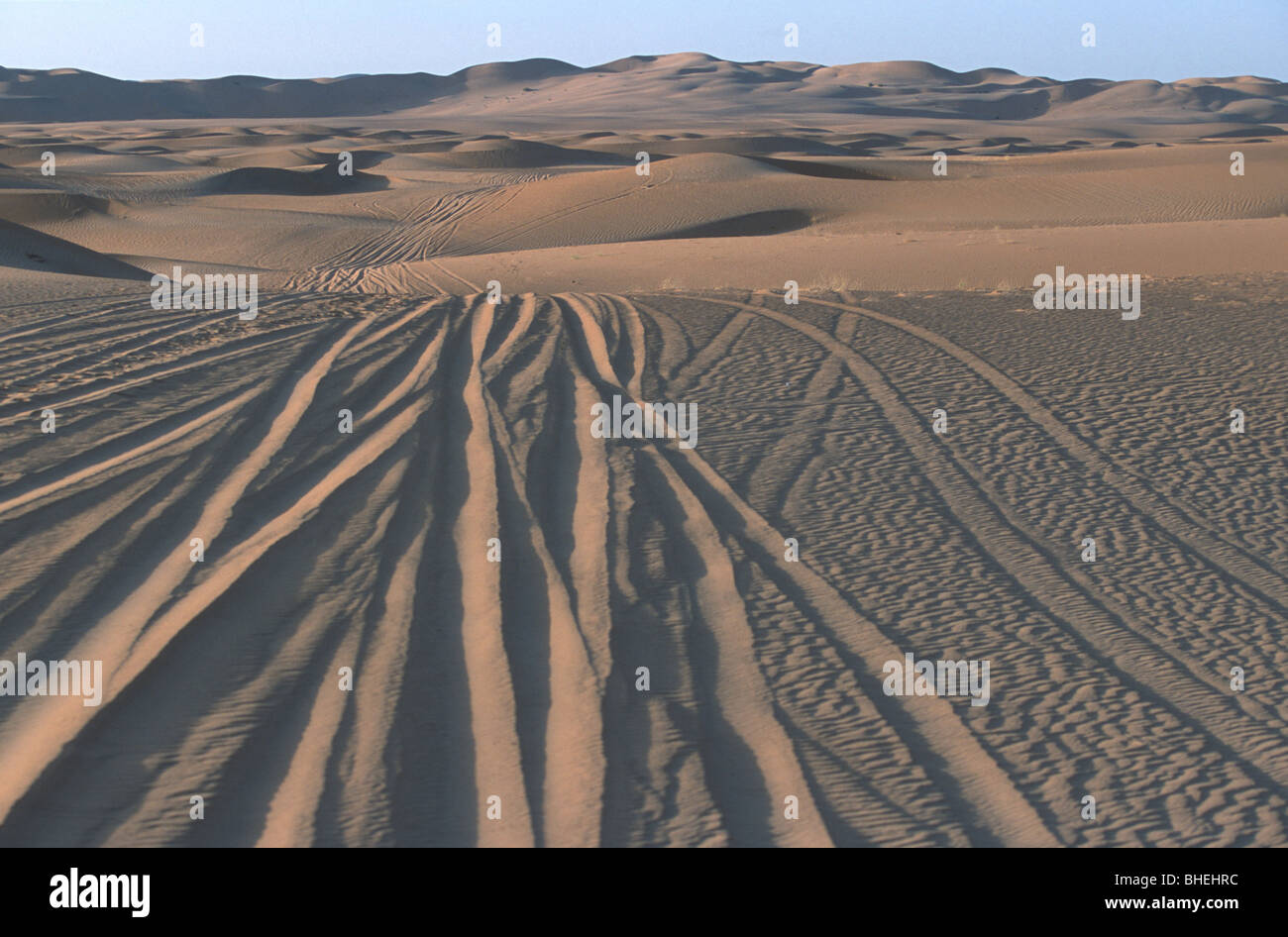 Vehicle tracks in the desert at sunrise, at Ramlat As Sabatayn, Yeman ...