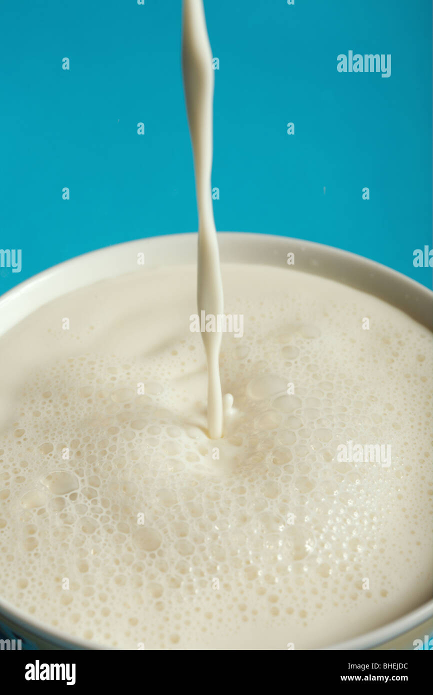 Portion of fresh cow milk on a dark blue background Stock Photo - Alamy