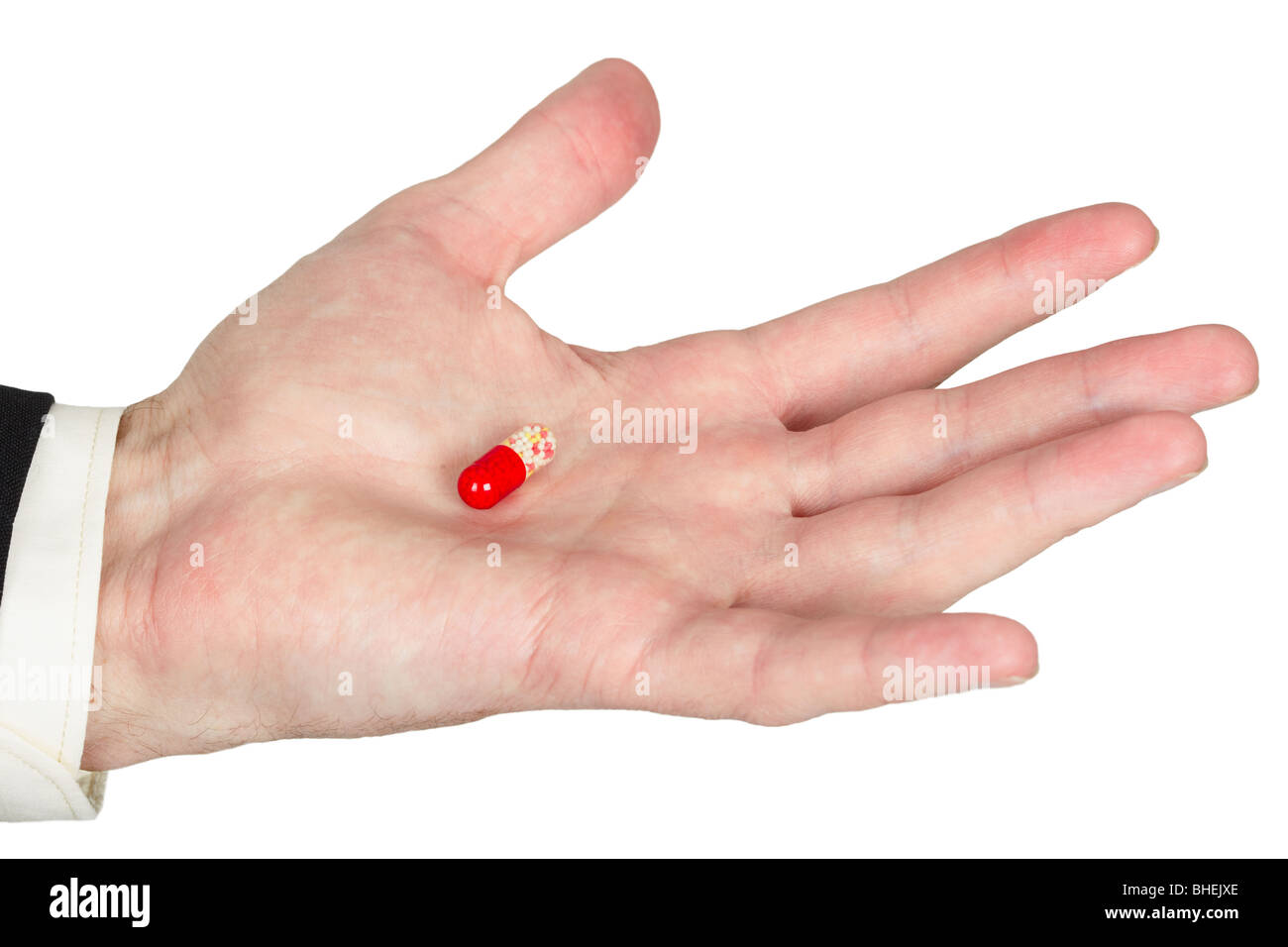 Man's hand with the red pill, white background Stock Photo - Alamy