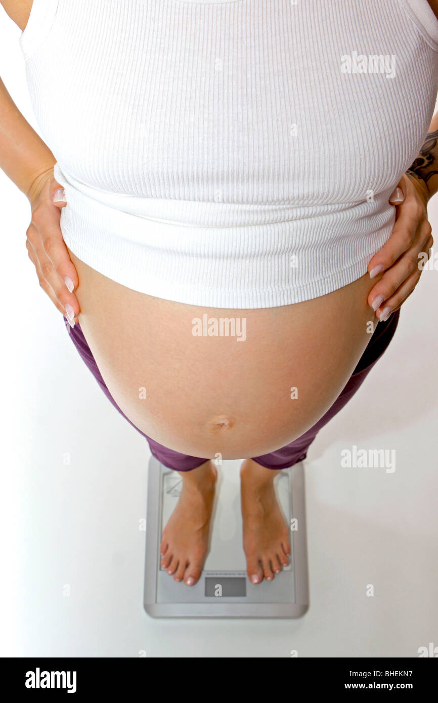 Pregnant woman controls her weight on a scale Stock Photo - Alamy