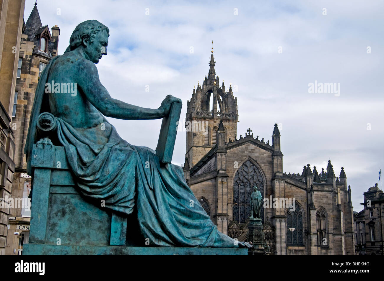The statue of David Hume on the Royal Mile with St Giles Cathedral ...