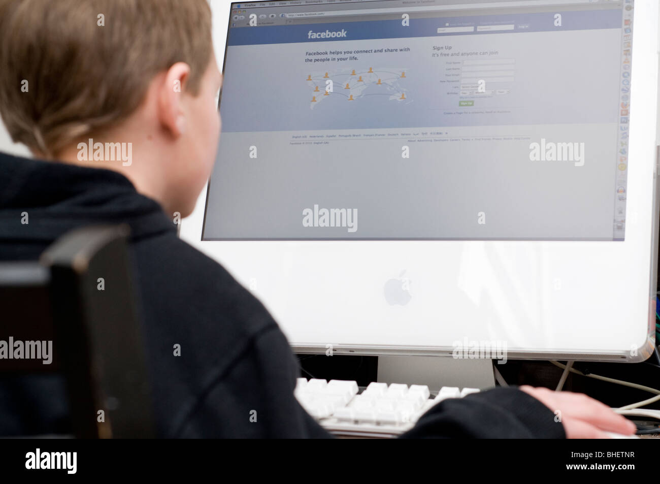 A young boy surfing on the internet and visiting the Facebook website ...