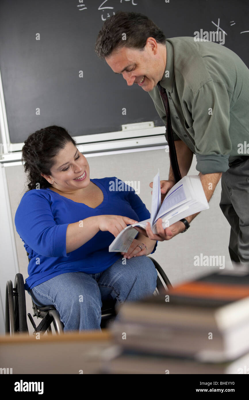 Professor teaching disabled student in a classroom Stock Photo - Alamy