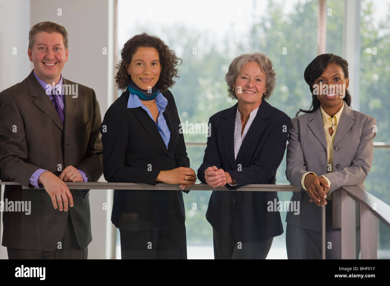 Business executives leaning against a railing Stock Photo - Alamy