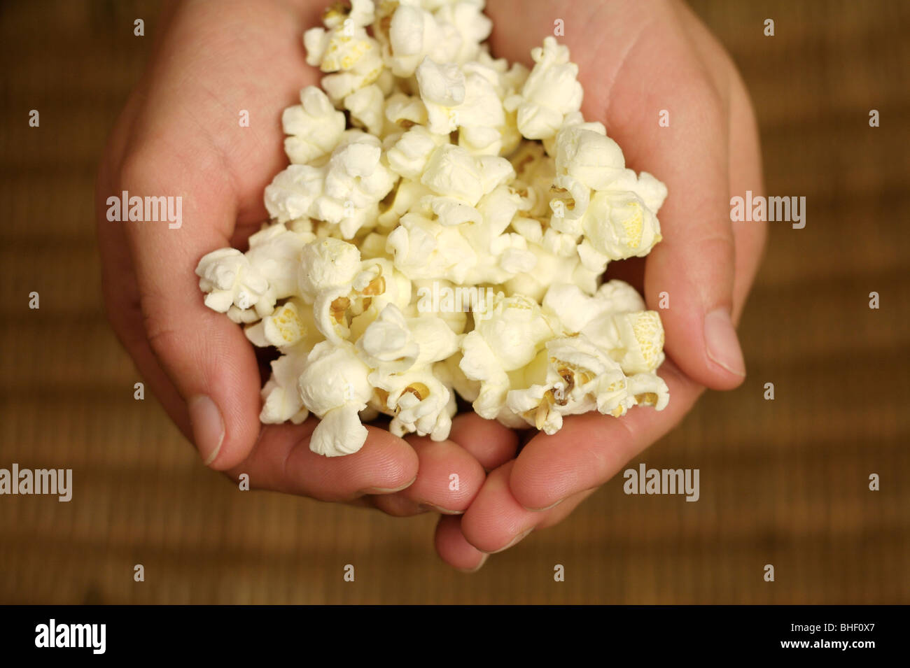 Hands full of popcorn Stock Photo - Alamy