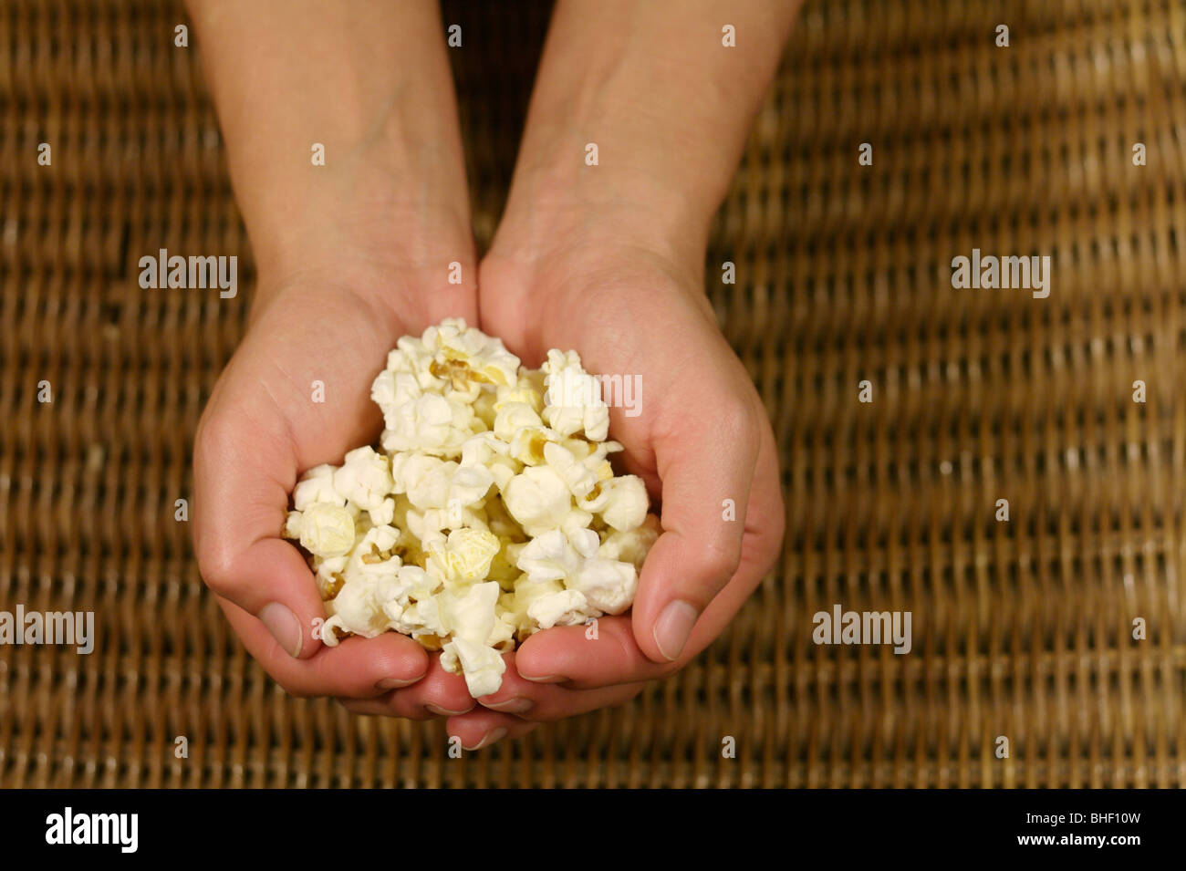 Hands full of popcorn Stock Photo - Alamy