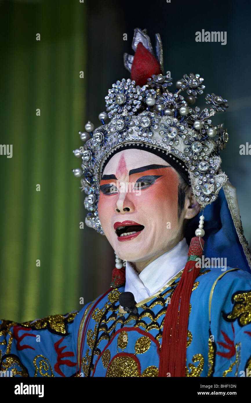 Chinese opera actor on stage in traditional colourful costume and make ...