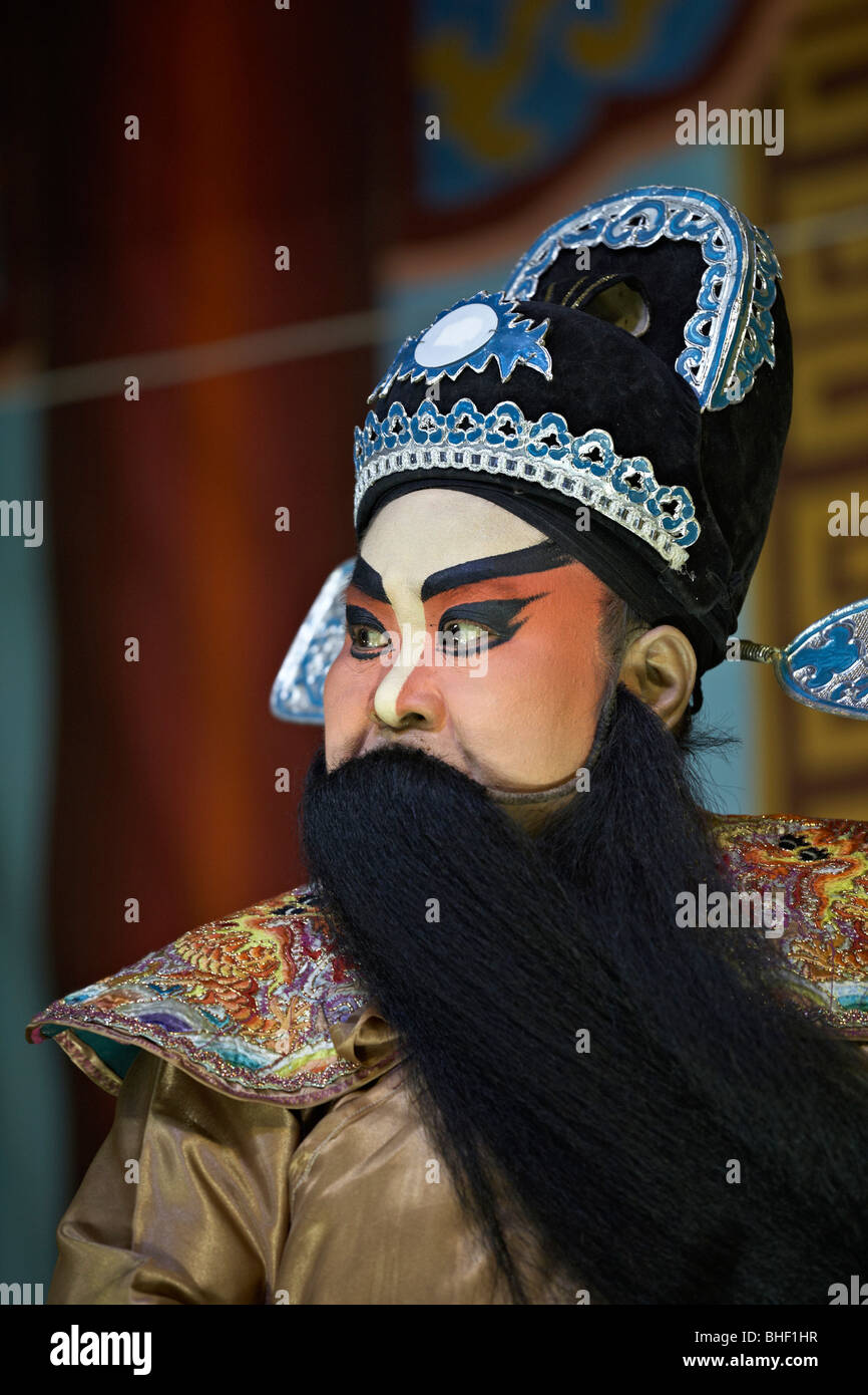 Chinese opera actor on stage in traditional colourful costume and make ...