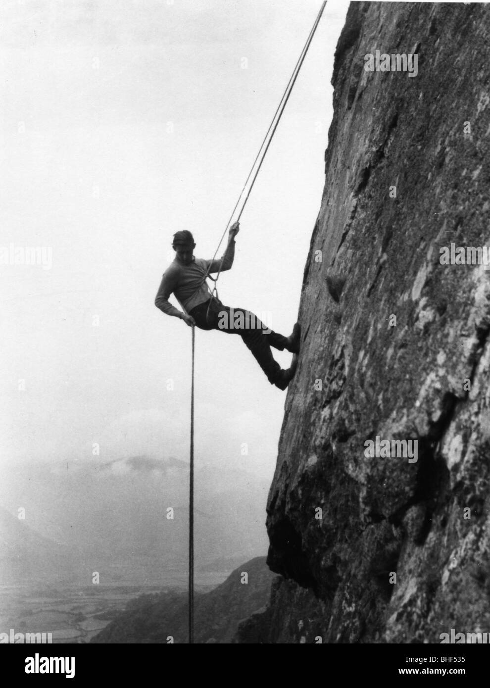 Boy abseiling down rock face, Outward Bound School, Eskdale, Cumbria ...