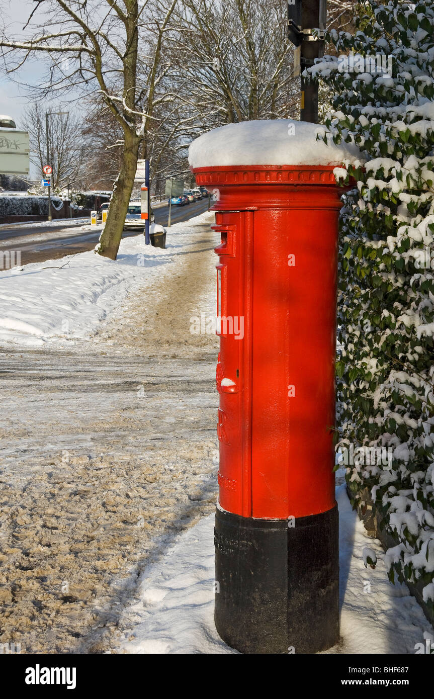 Traditional red postbox post box covered in snow in winter York North ...