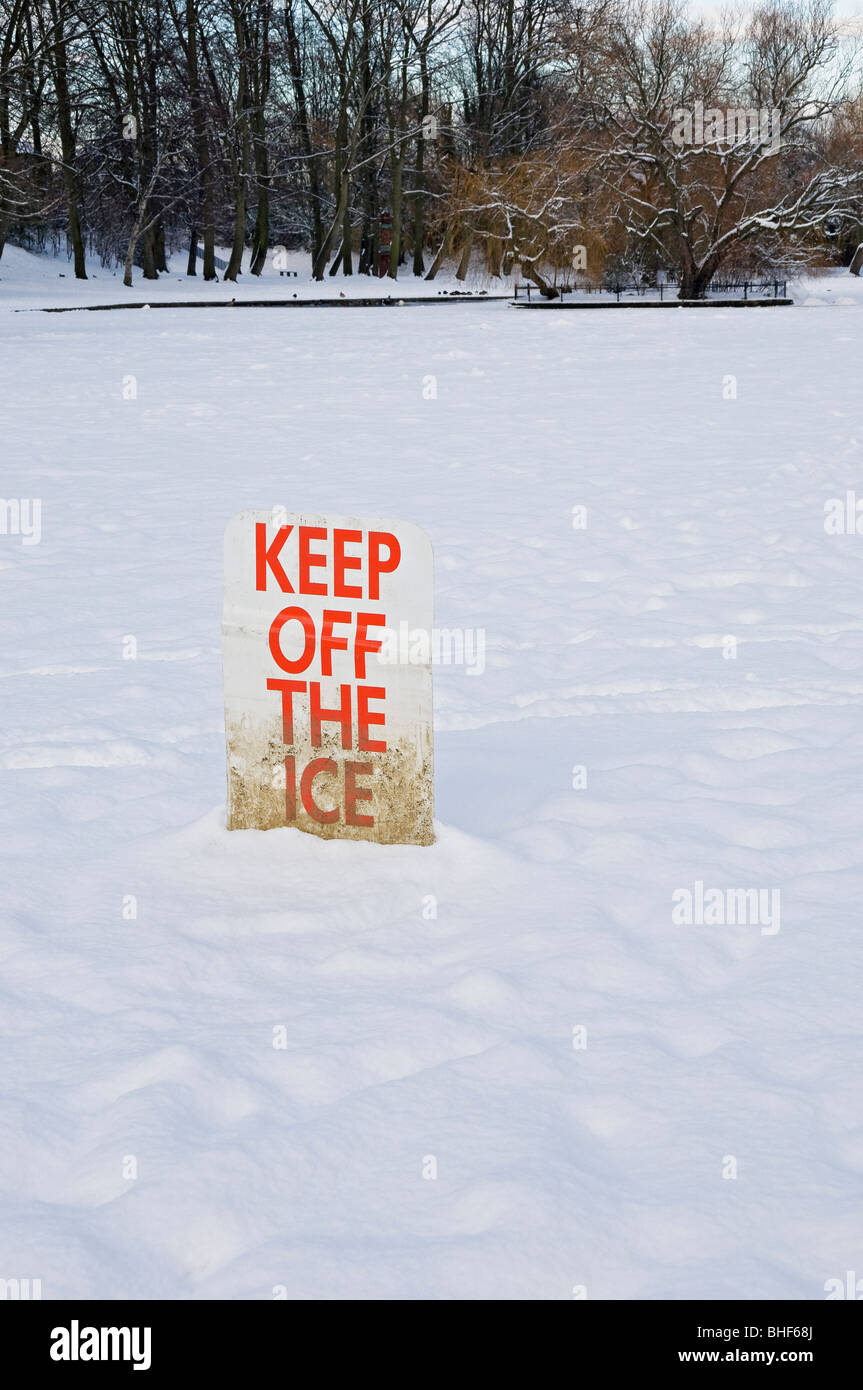 Keep off the ice sign on the frozen lake covered in snow in winter ...