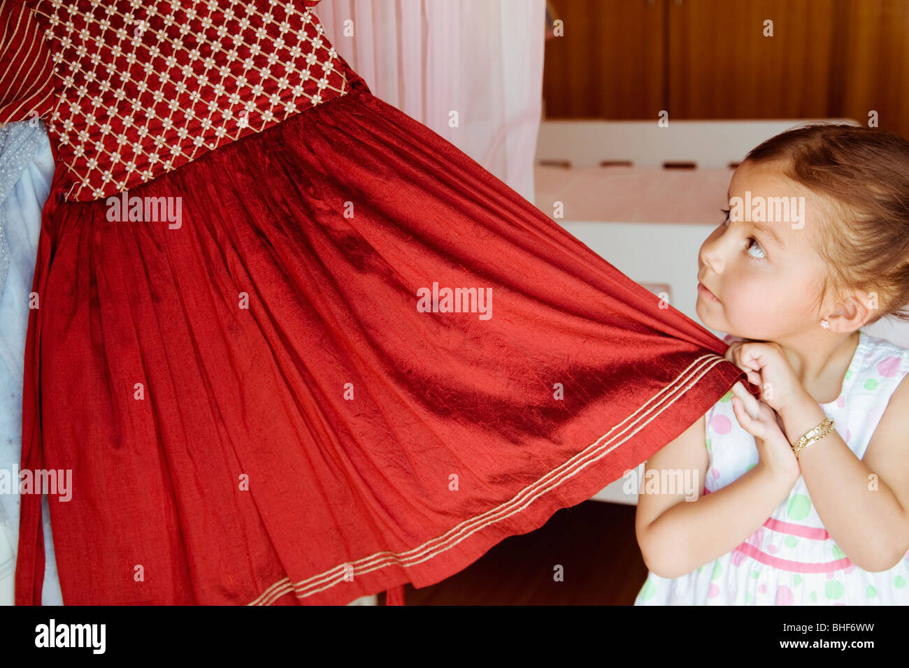 Hispanic girl taking costume from closet Stock Photo - Alamy