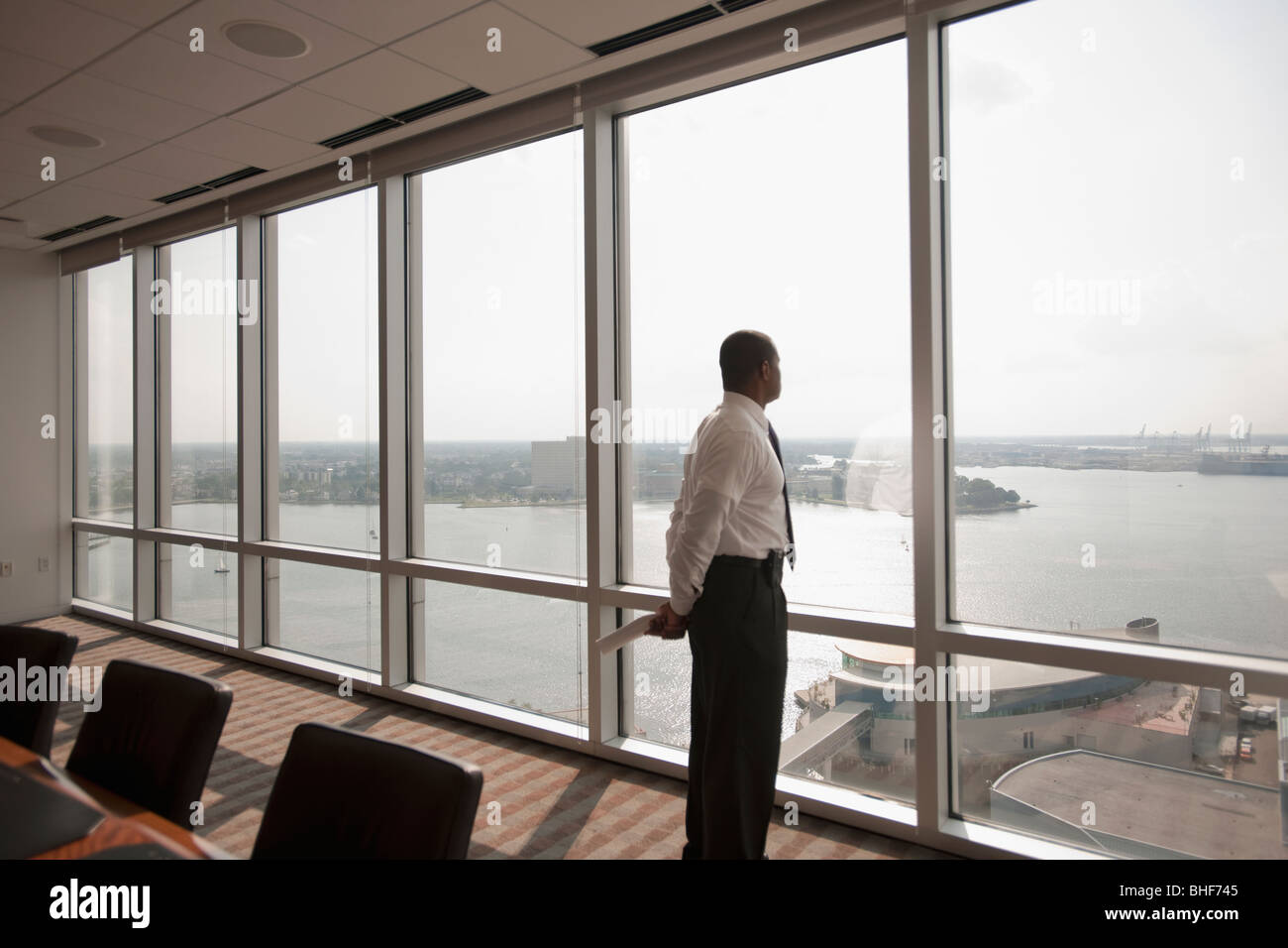 African American businessman looking out office window Stock Photo - Alamy