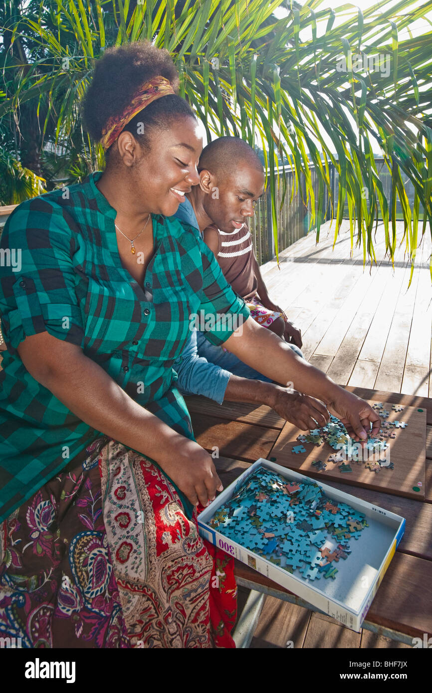 African American woman solving puzzle with family on patio Stock Photo ...