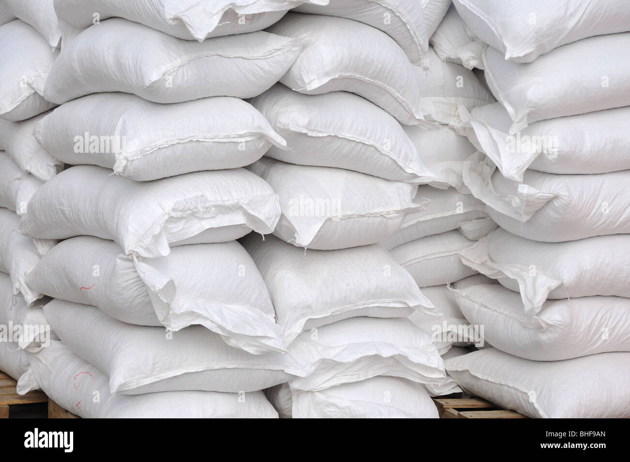Stacked white sacks at storehouse Stock Photo - Alamy