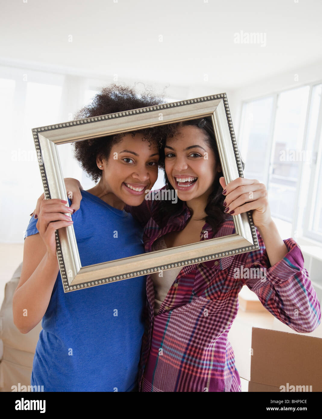 Friends looking through empty frame Stock Photo - Alamy