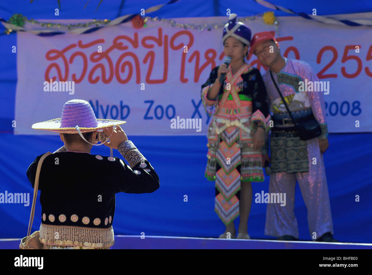 Hmong man taking pictures of Hmong couple on stage dressed in ...