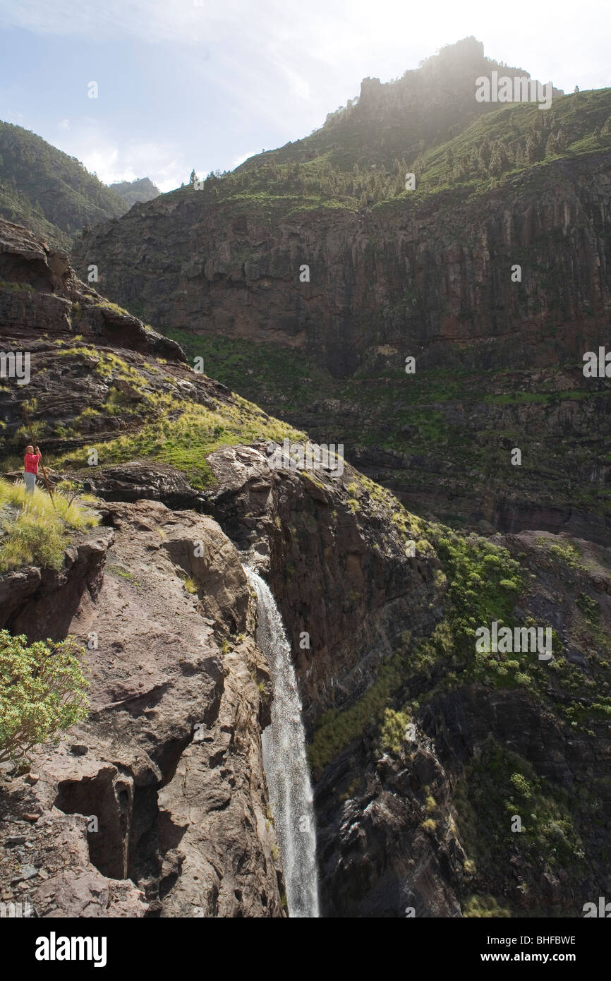Hiker in the mountains at the waterfall Cascada El Palmar, Valley of El ...