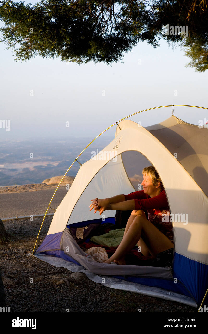 Young women waking up and stretching in her tent, Mount Foia, 902 ...