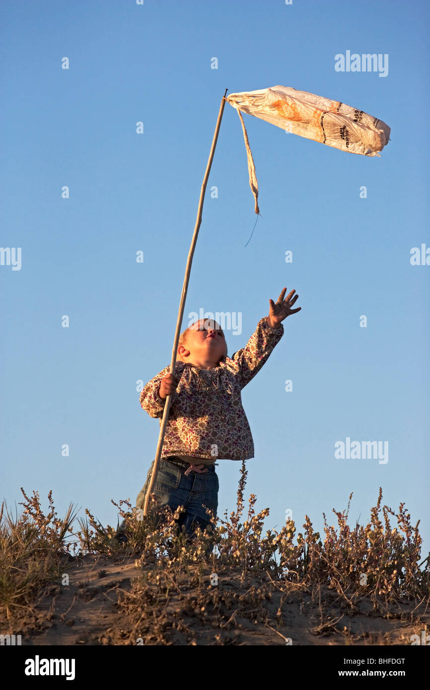 Little girl on a sand dune grasping at a vane, Punta Conejo, Baja ...