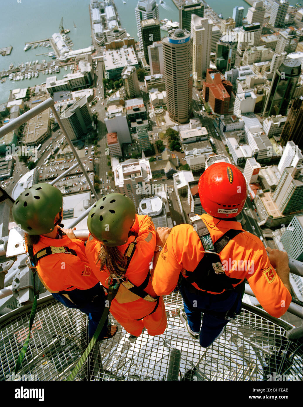 Three people on top of Sky Tower looking over Central Business District ...