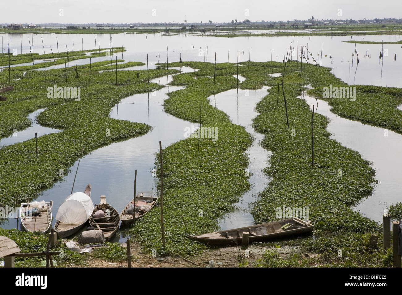 Water canals and boats under clouded sky south of Phnom Penh, Cambodia ...