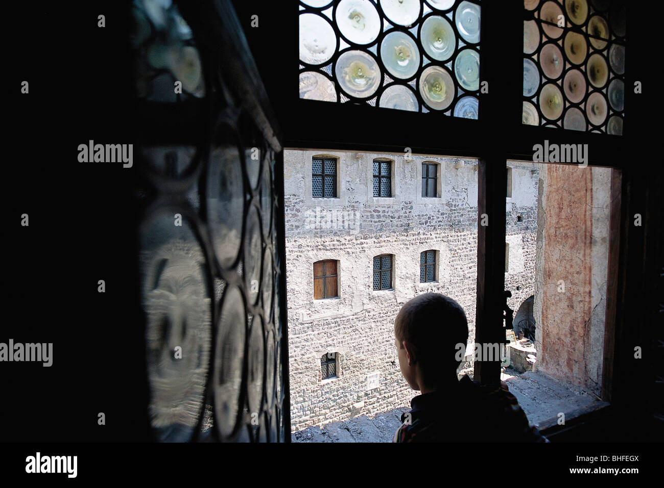 A boy looking out of a window at the atrium of Runkelstein castle ...