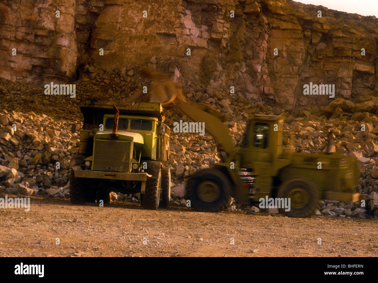 Giant Caterpillar quarry dump truck being filled by a front loader ...
