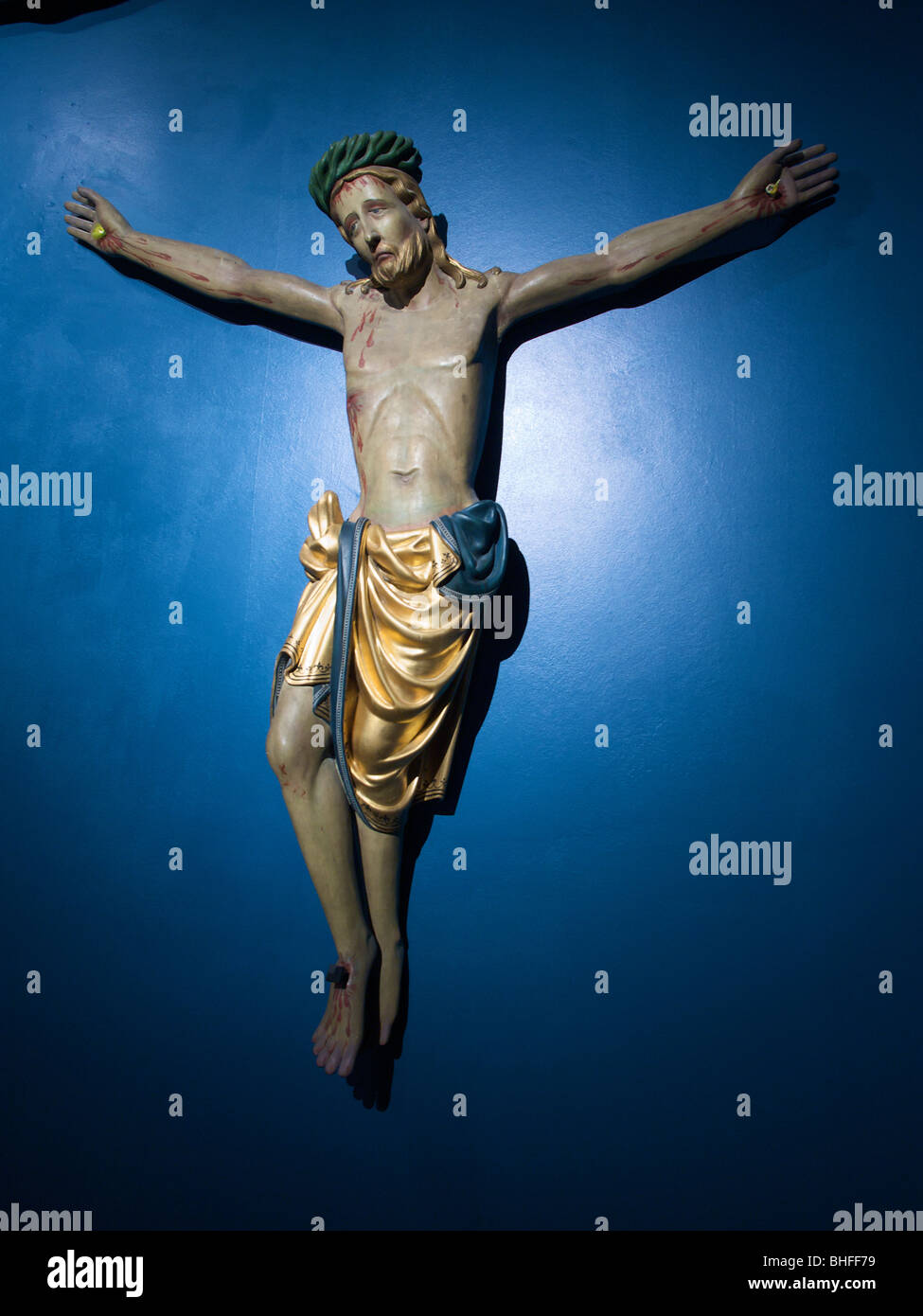 religious art sad looking Jesus hanging on a blue wall in a museum in ...
