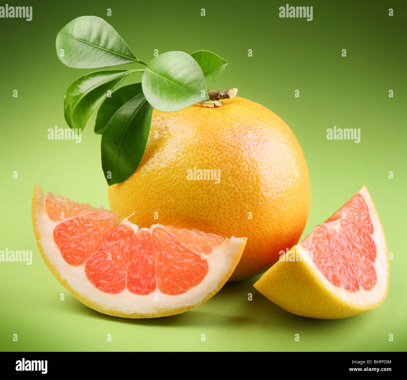 Ripe grapefruit with segment on a green background Stock Photo - Alamy