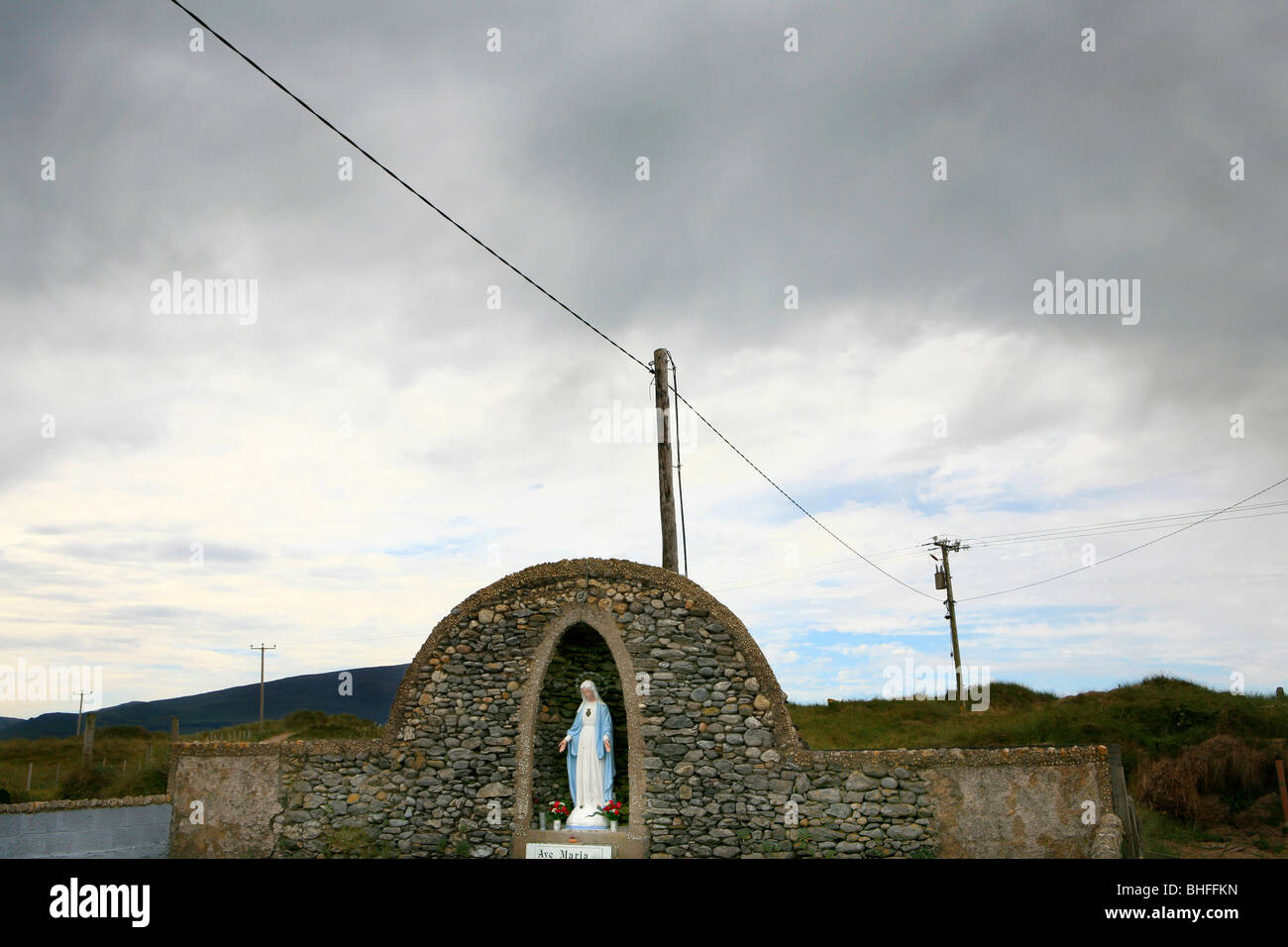 Statue of Virgin Mary under grey clouds, Magharees, Stradbally Strand ...