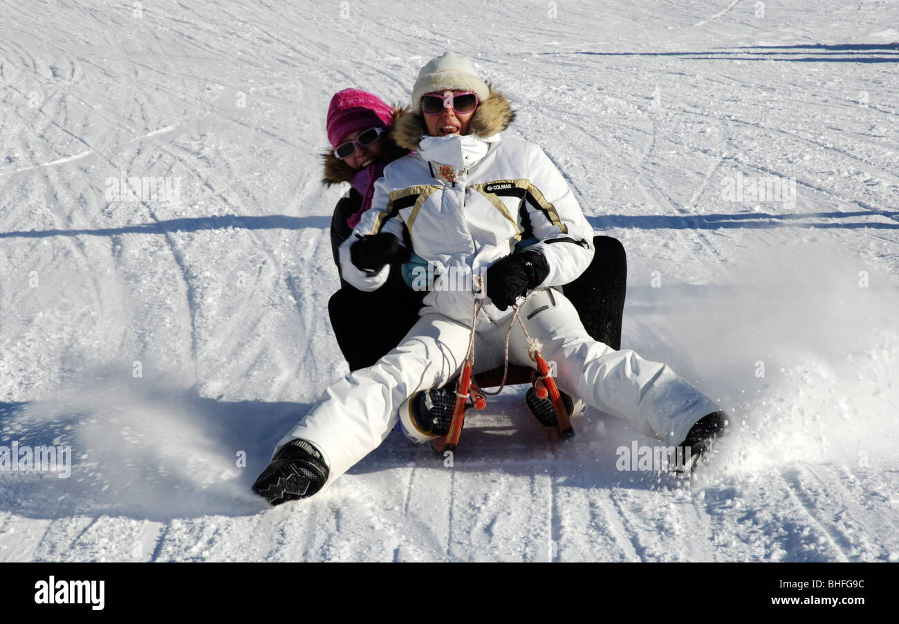 Two women on a sledge, sledging down a slope, Fun in the snow, South ...