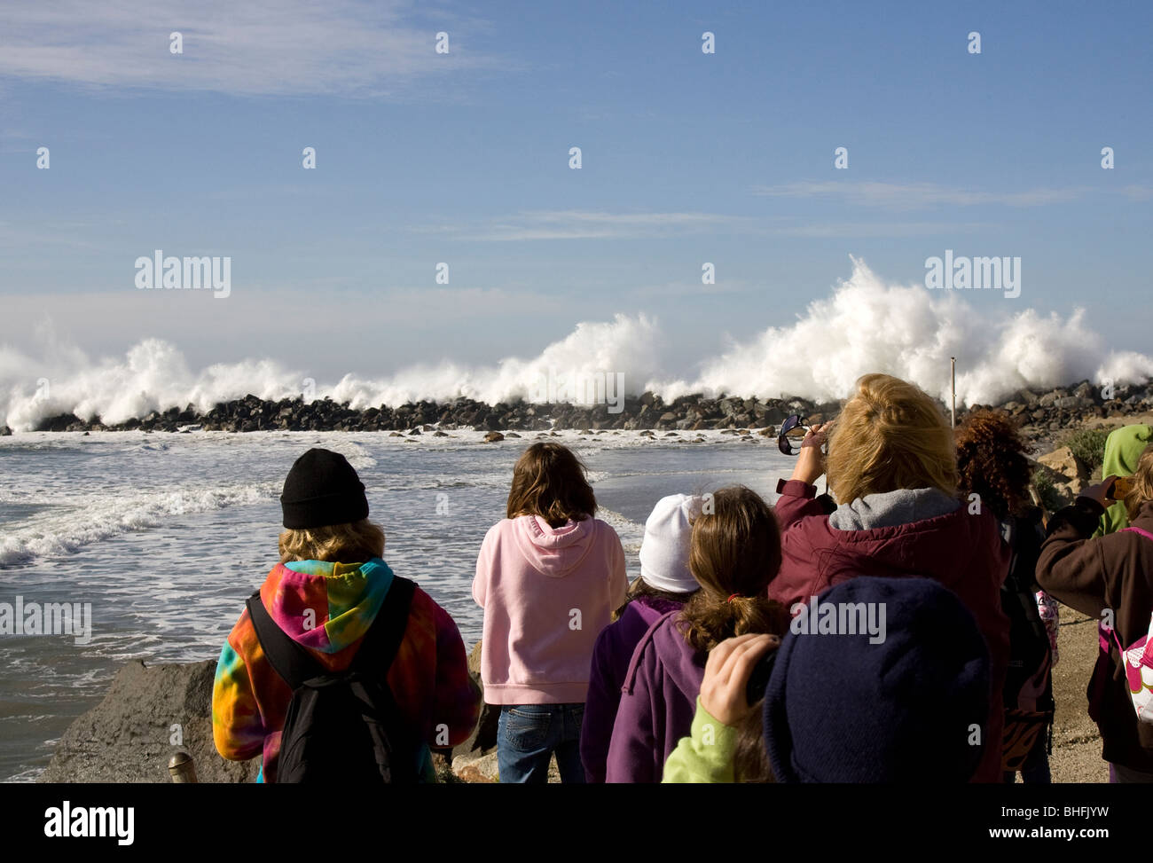 Group of People Watching Waves Crash over Breakwater Stock Photo - Alamy